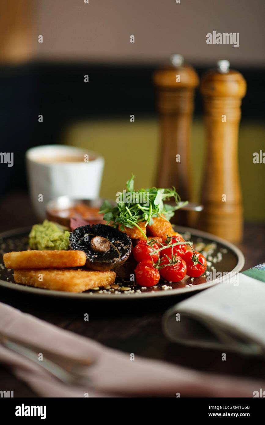 English Breakfast on a black ceramic plate. Wooden table. Full English ...