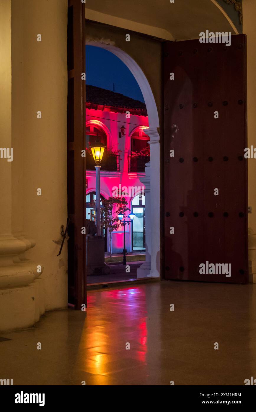 Garishly lit McDonald's seen through the open door of the cathedral, in ...