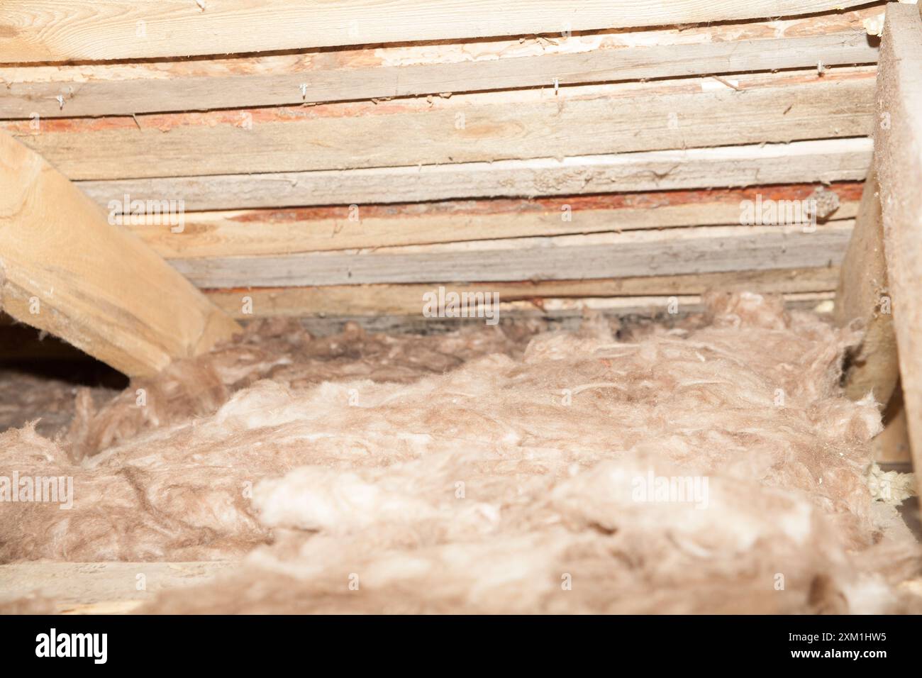 Construction worker mineral wool thermally insulating house attic with ...