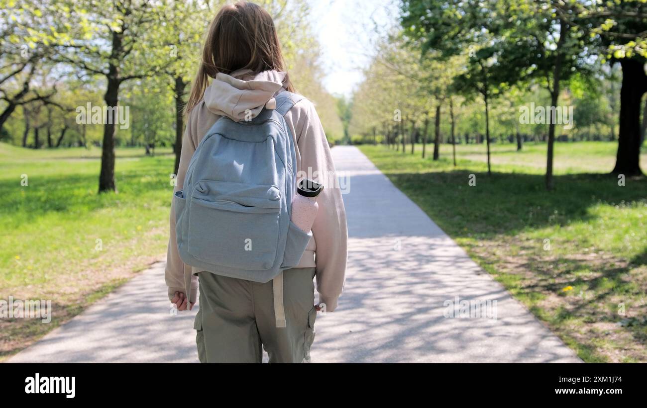 Small Girl Carrying Backpack Walking Home After School, From Behind ...