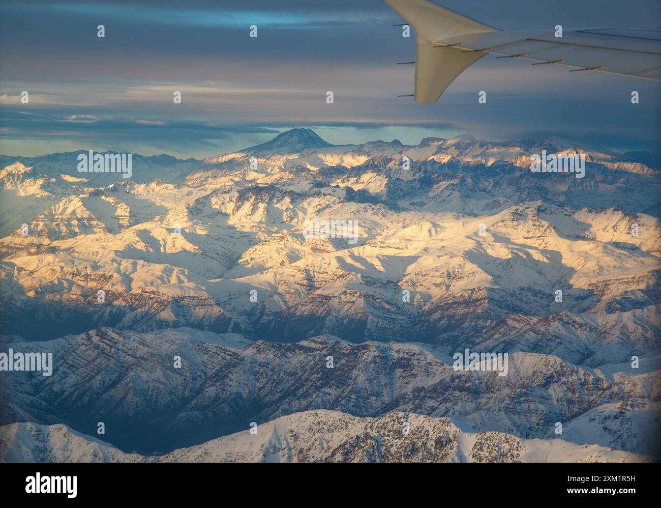 Aerial view of the Andes Mountains covered in snow and the tip of the ...