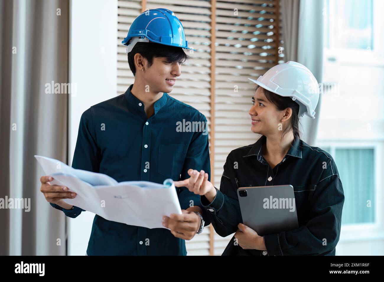 Two Engineers Discussing Blueprint and Project Plans at a Construction ...