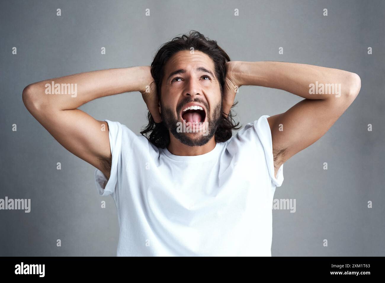 Frustrated, man and ear with scream in studio for sensory overload ...