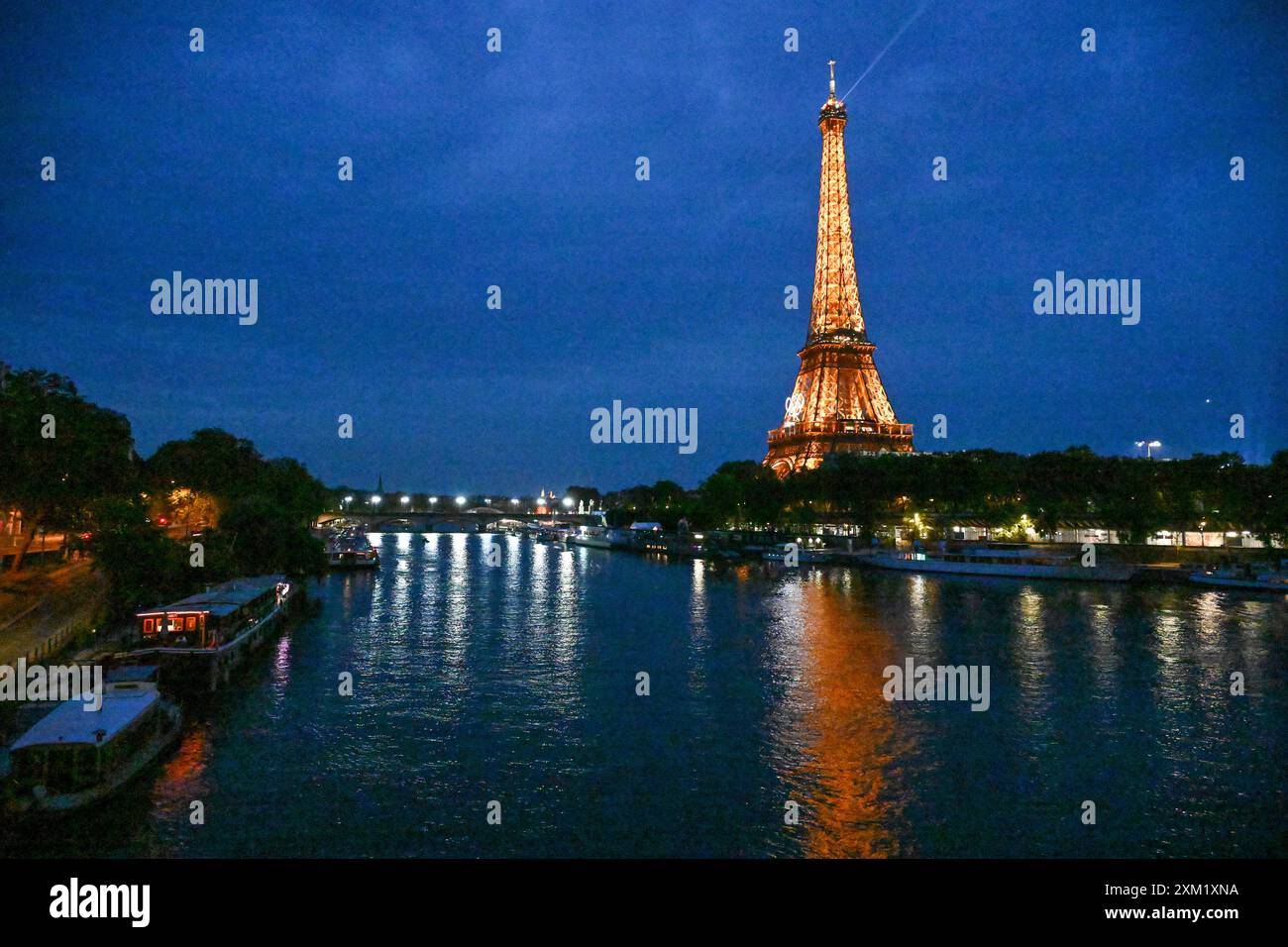 the illuminated Eiffel Tower and the Saine River with the five Olympic ...