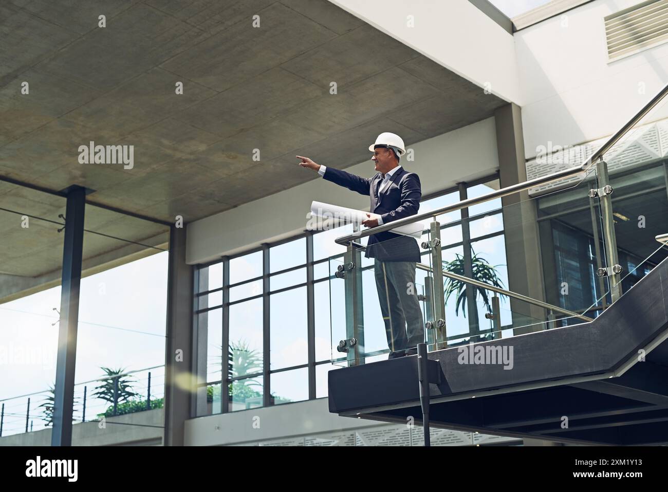 Blueprint, man and engineer pointing at construction site for office ...