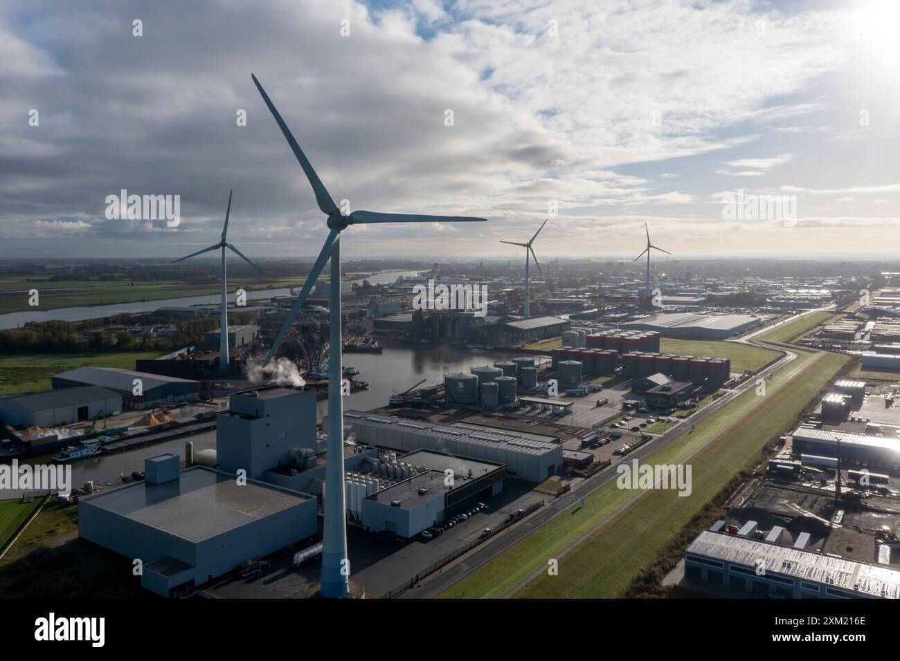 The image shows an aerial perspective of a city featuring wind turbines ...