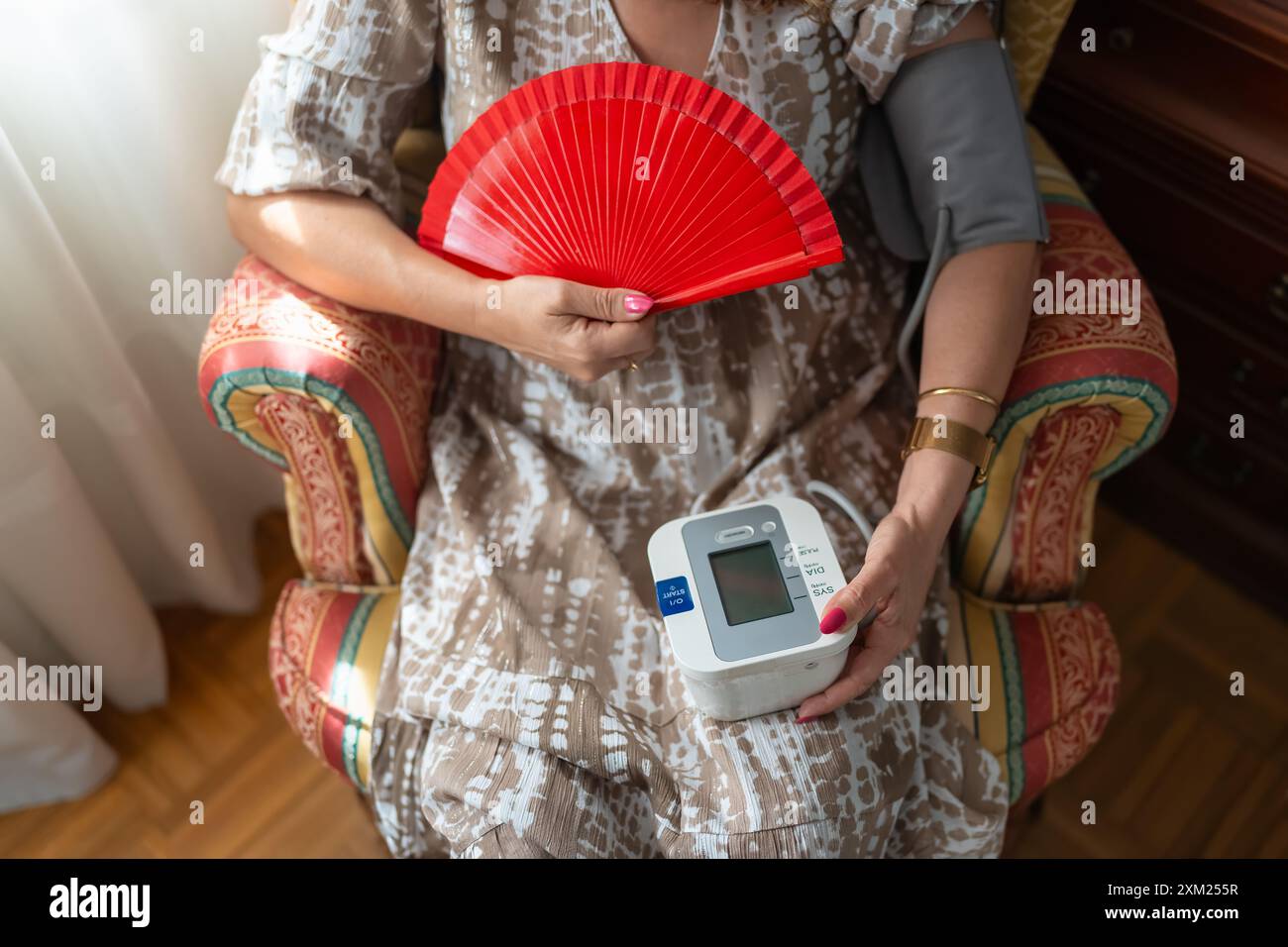 Woman with a fan giving herself air due to the heat and with a blood ...