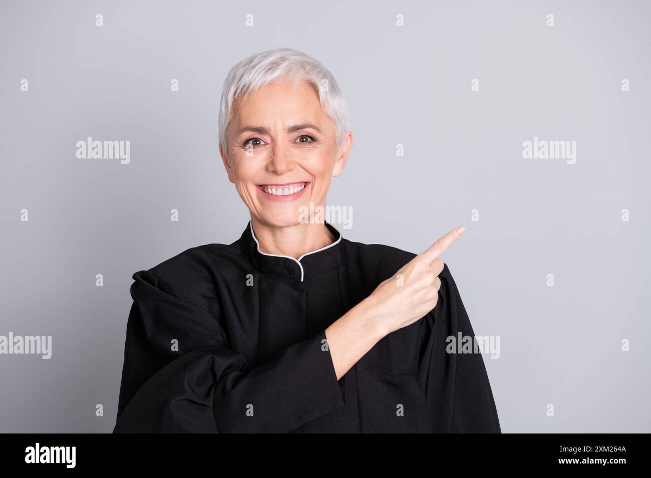 Photo of smiling judge senior woman point finger empty space isolated ...