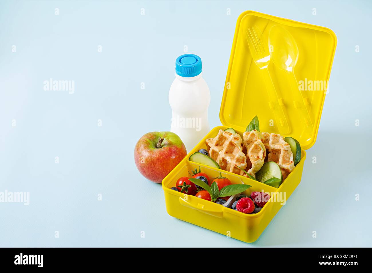 Kids lunch box with zucchini waffles, cucumber, cherry tomatoes and ...