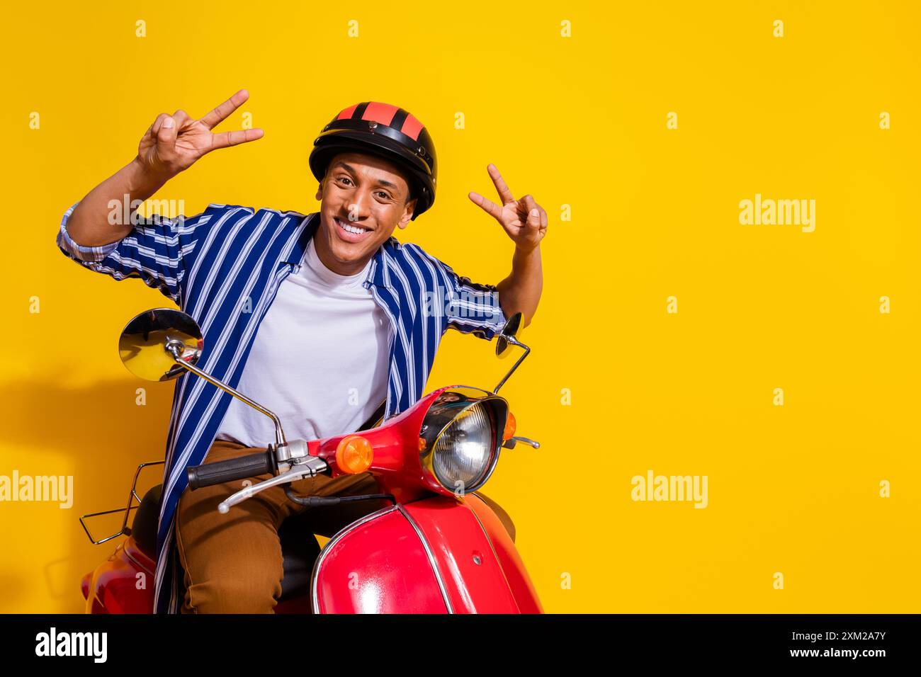 Photo of friendly cheerful man dressed striped shirt in helmet sit on ...