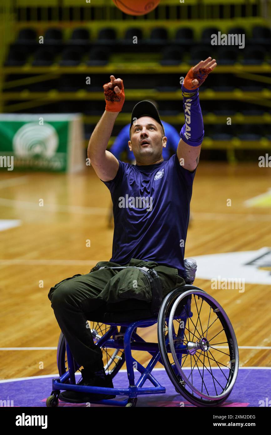 Amputee athlete in a wheelchair throwing a ball on court. Kyiv - 12 ...
