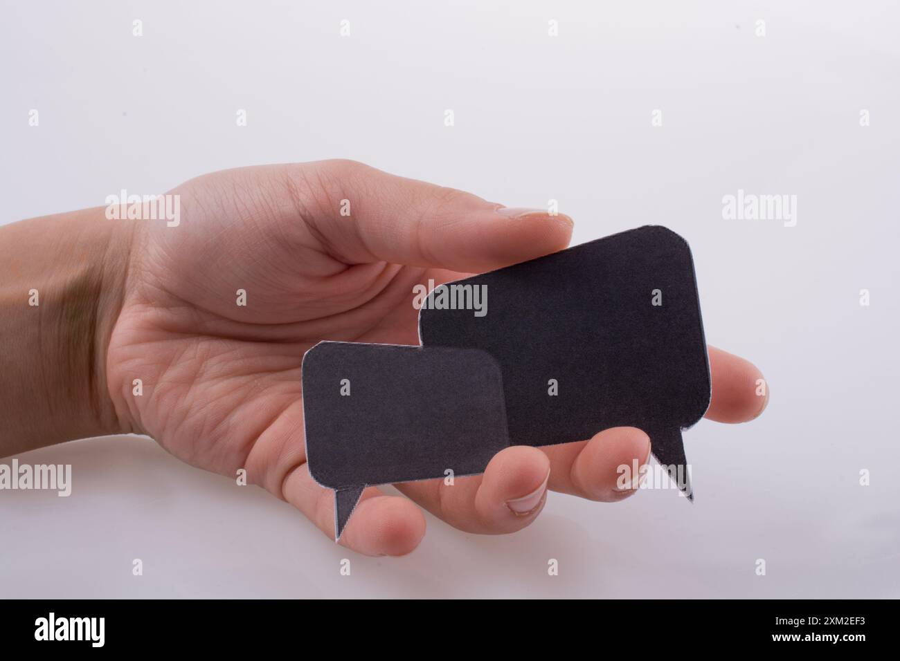 Hand holding dialogue boxes on a white background Stock Photo - Alamy