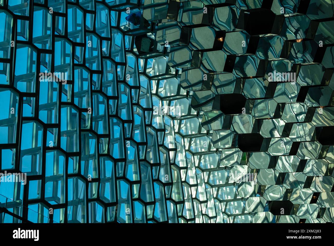 Modern building facade with hexagonal glass windows reflecting sky ...