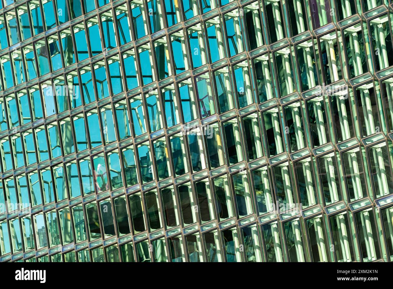 Modern glass facade reflects sky and urban architecture, showcasing ...