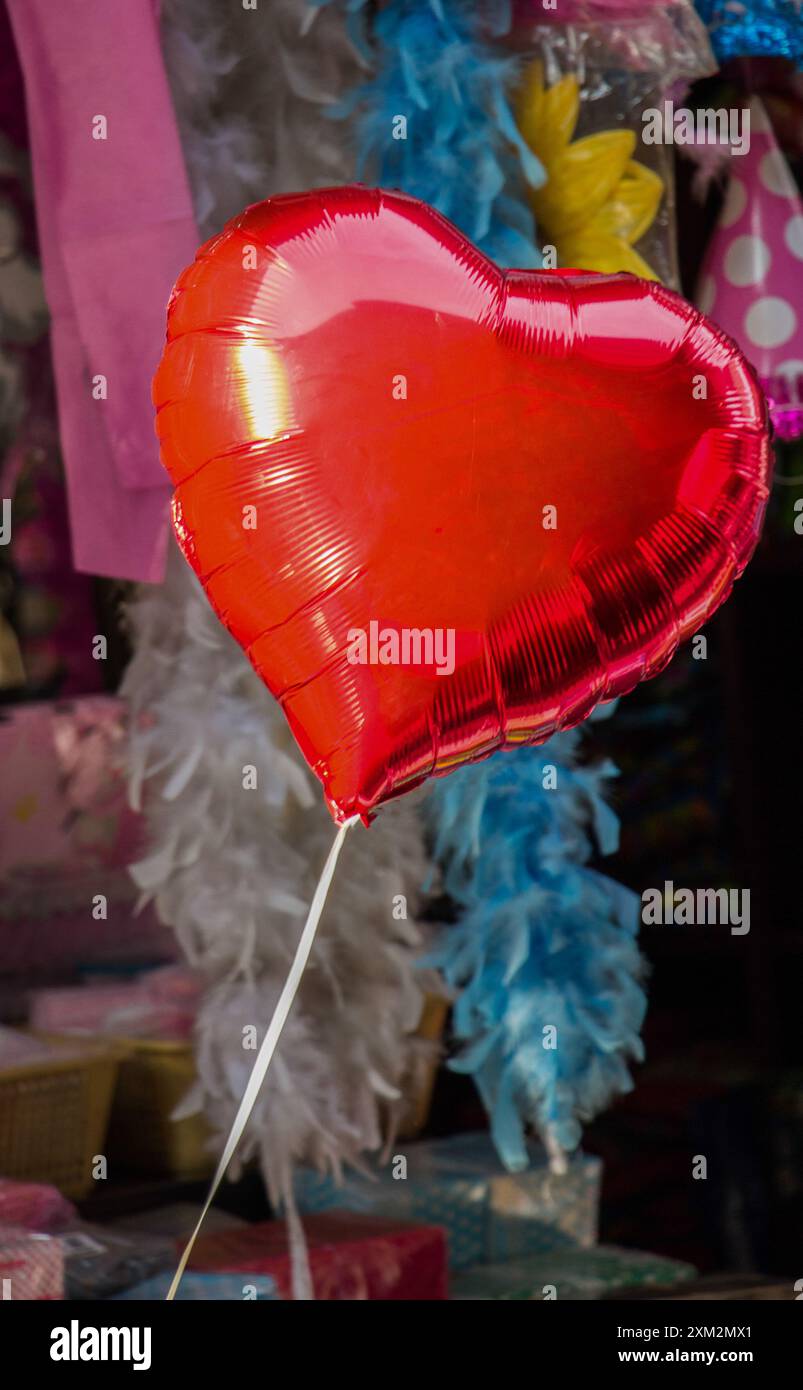 Little red color heart shape balloon in a bazaar Stock Photo - Alamy