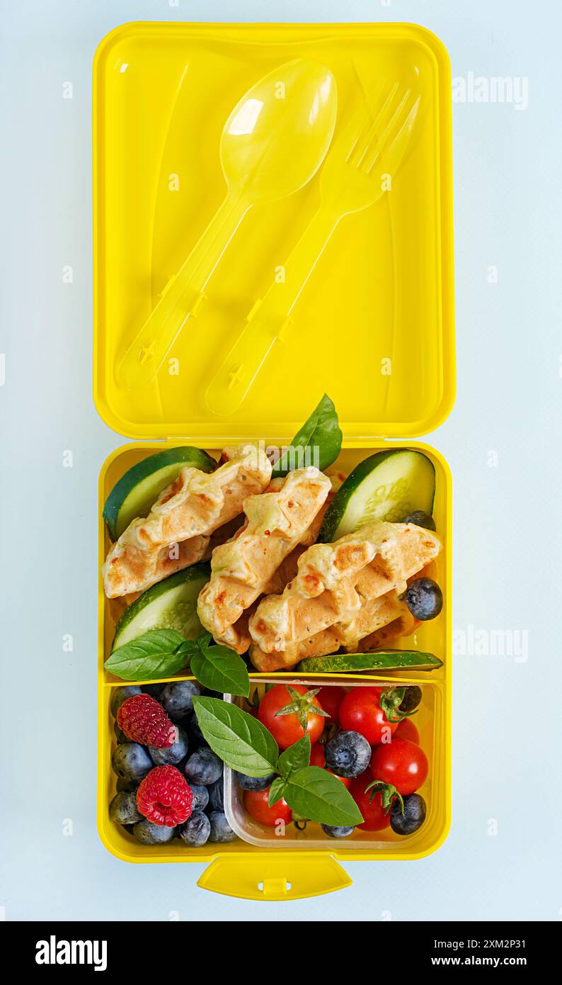 Kids lunch box with zucchini waffles, cucumber, cherry tomatoes and ...