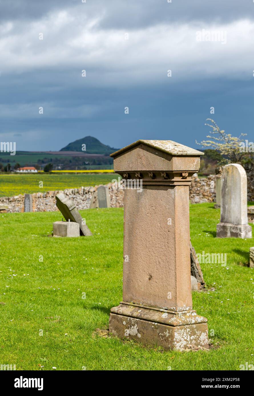 Old gravestone in cemetery at Athelstaneford with view to Berwick Law ...