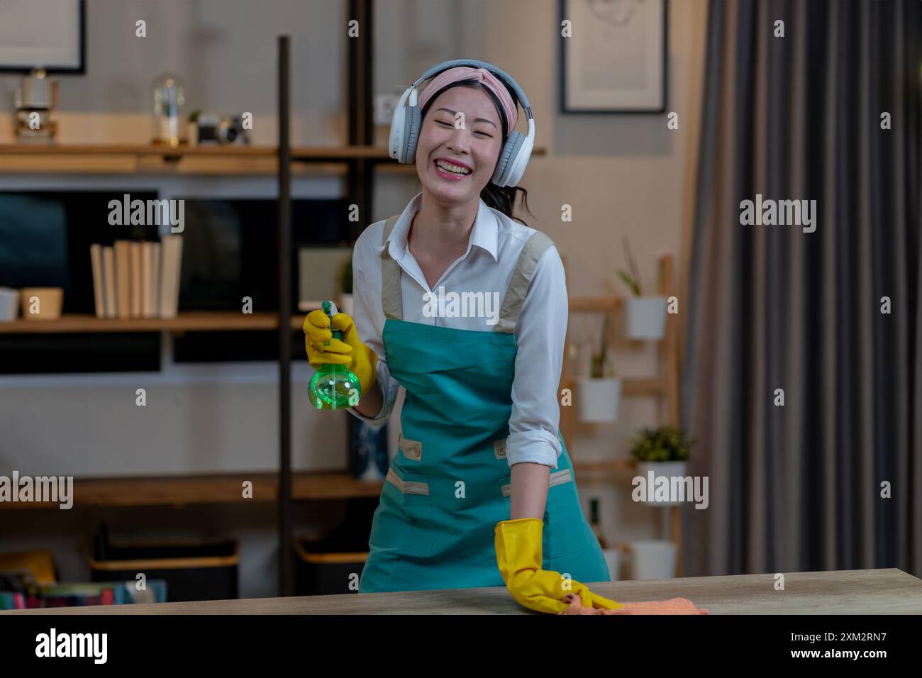 A young woman is happily singing while cleaning her house Stock Photo ...