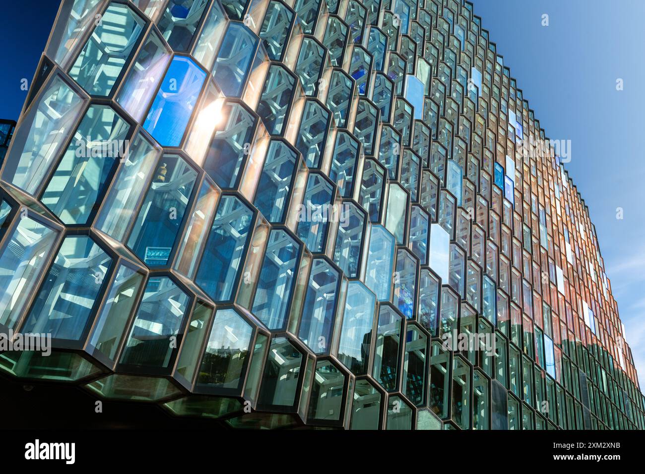 Modern glass building with geometric facade reflecting blue sky Stock ...