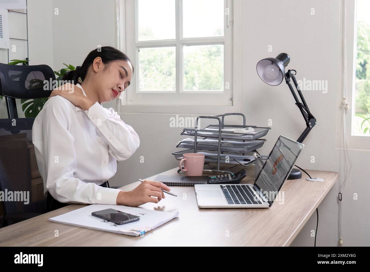 Young Woman Experiencing Neck Pain While Working at Desk in Modern ...