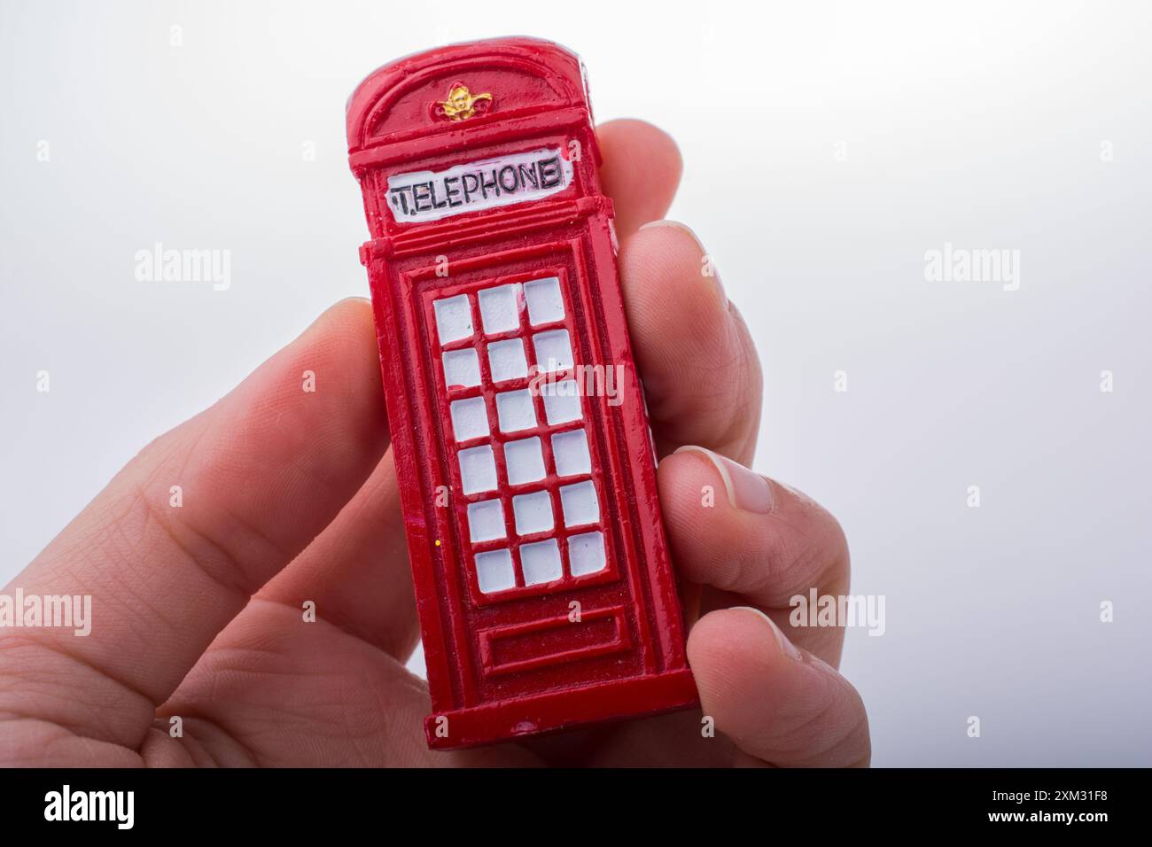 Hand holding a red color phone booth on a white background Stock Photo ...