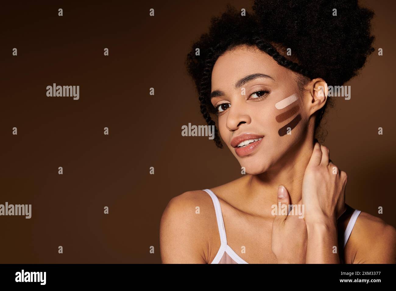 A young African American woman with a warm smile stands against a beige ...