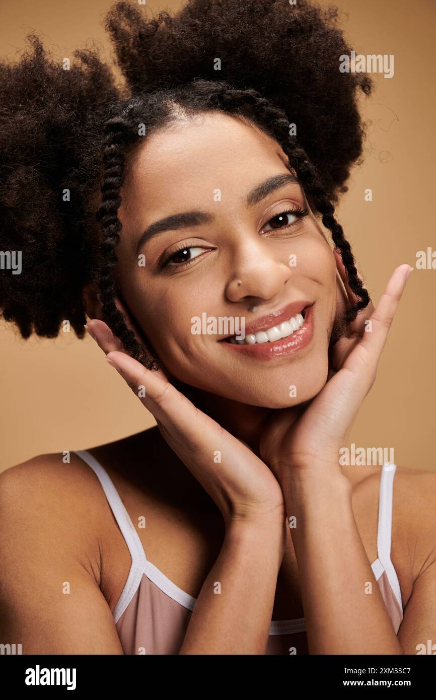Smiling young Black woman with glowing skin against beige background in ...