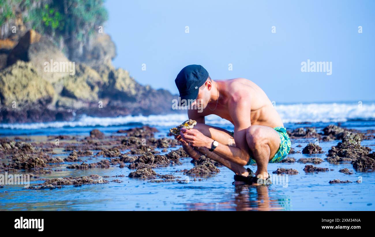 People looking for sea animals in gondo mayit beach Stock Photo - Alamy