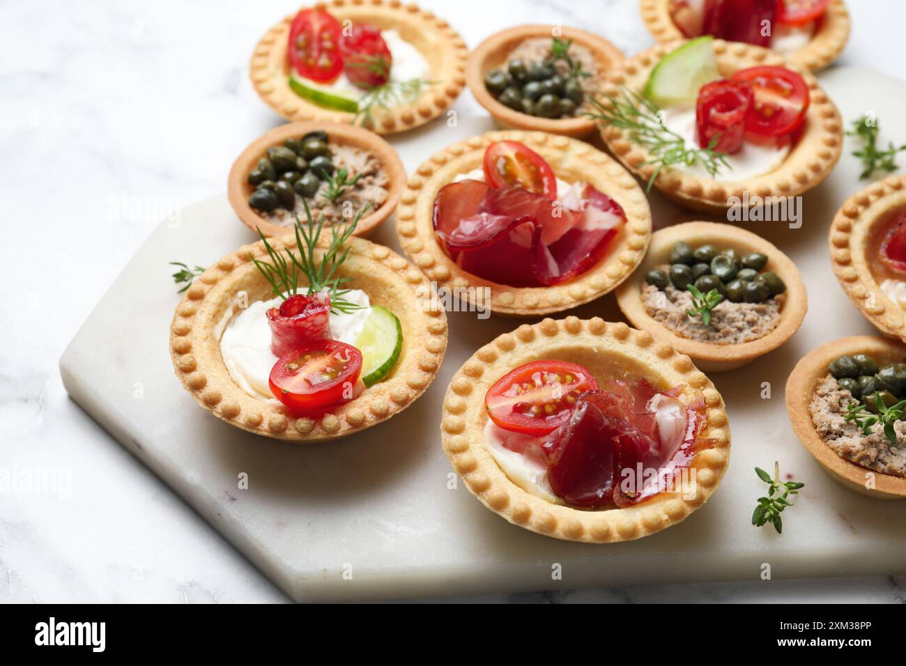 Different delicious canapes on white marble table Stock Photo - Alamy