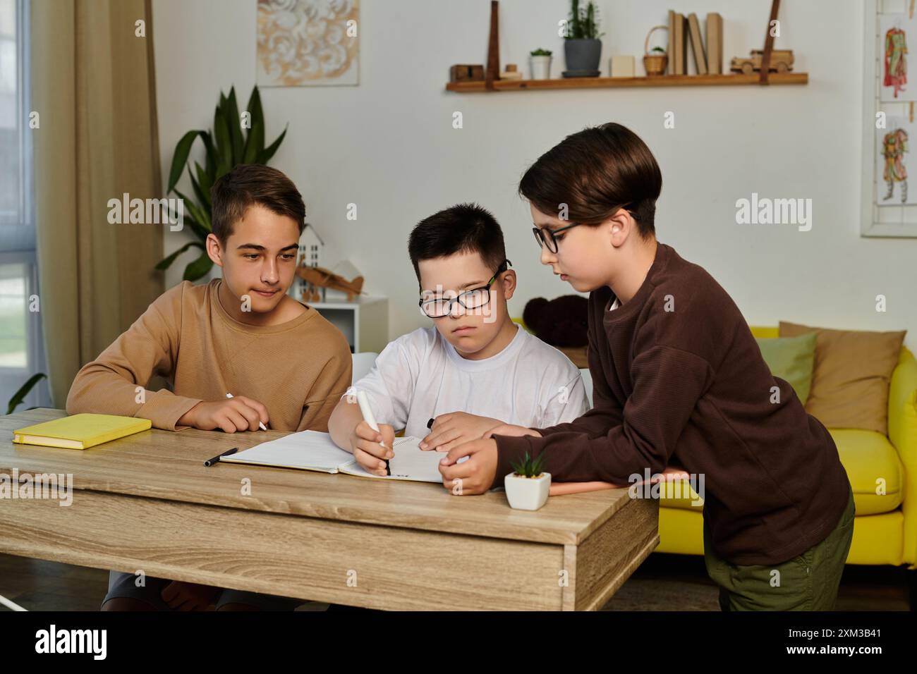 Three young boys work together on a school project at home Stock Photo ...