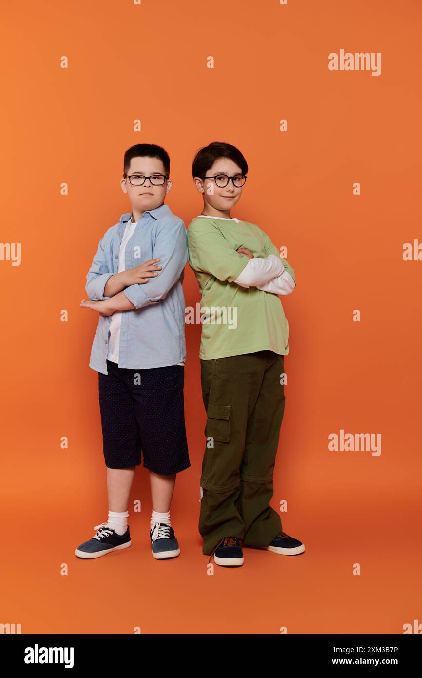 Two boys, one with Down syndrome, stand with arms crossed in front of ...