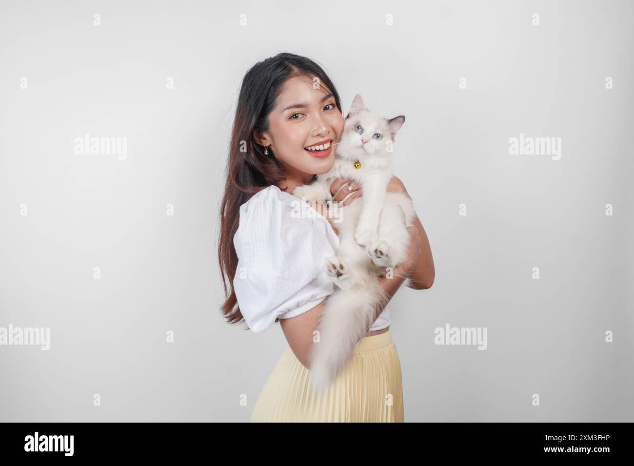 Portrait of young Asian woman holding cute ragdoll cat with blue eyes ...