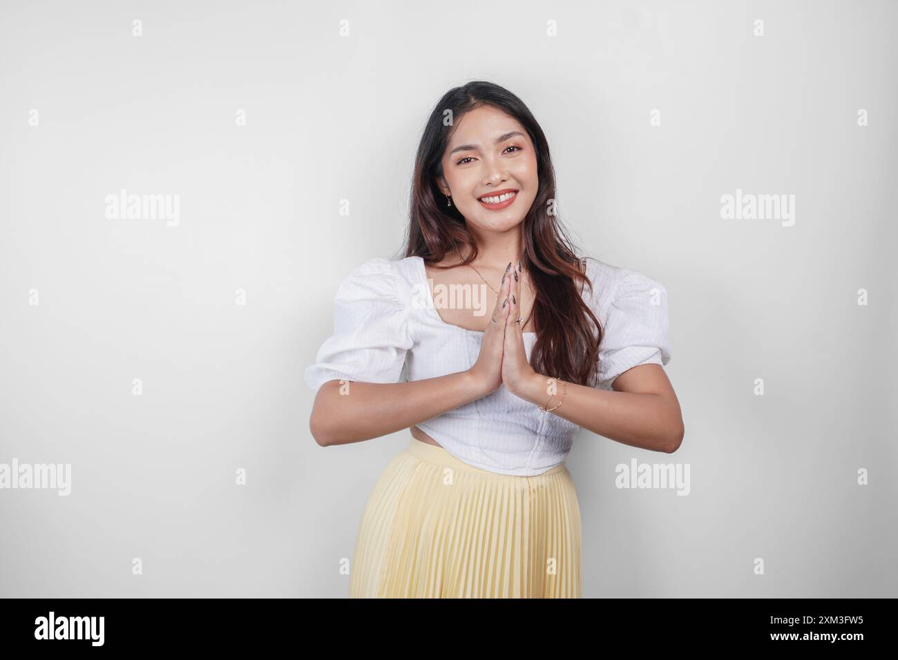 Friendly Asian woman is giving gestures of traditional greetings by her ...