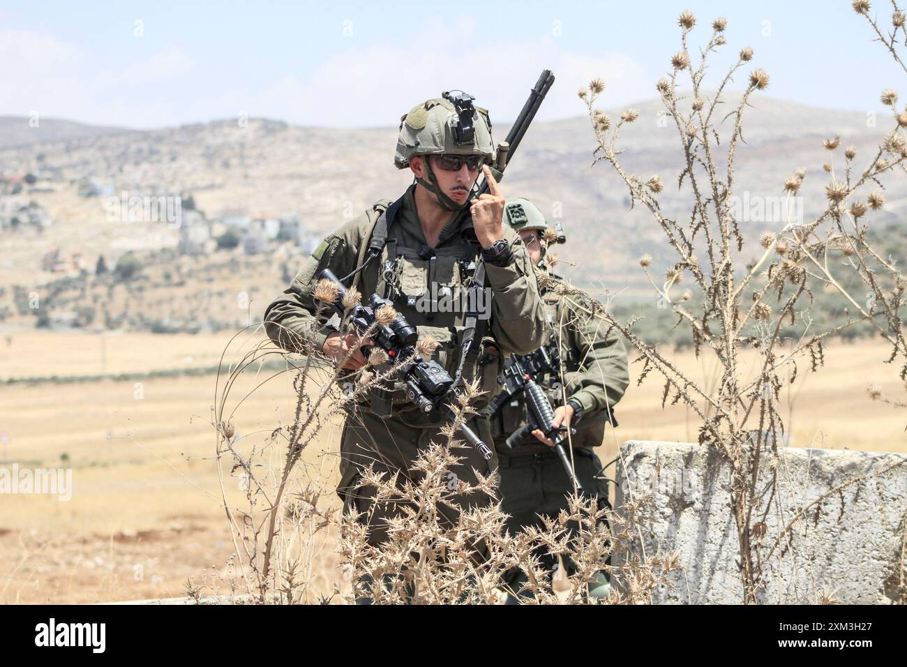 Israeli soldiers search near one of the checkpoints located south of ...