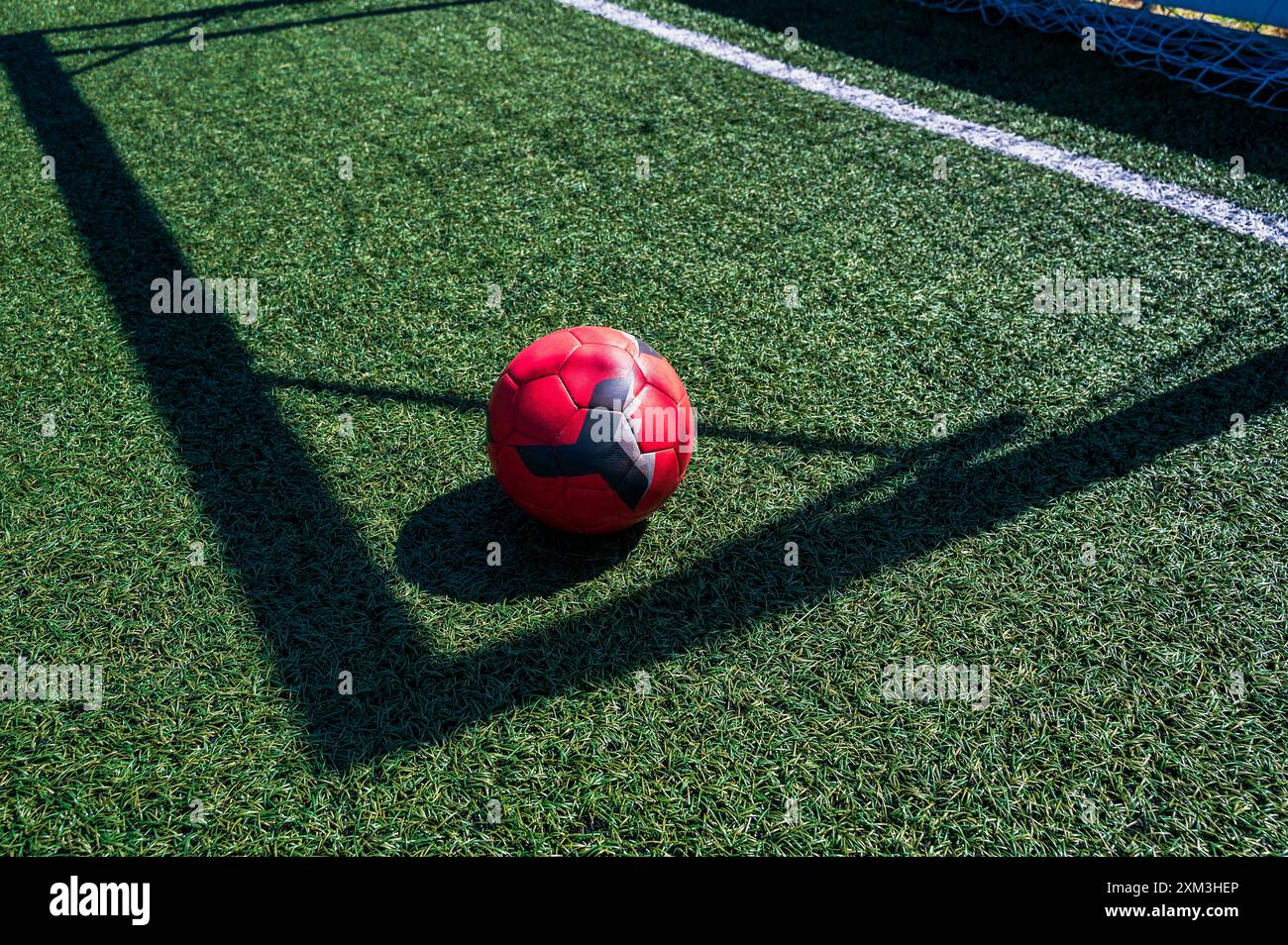 A soccer ball lies on the ground in a green field in natural light ...