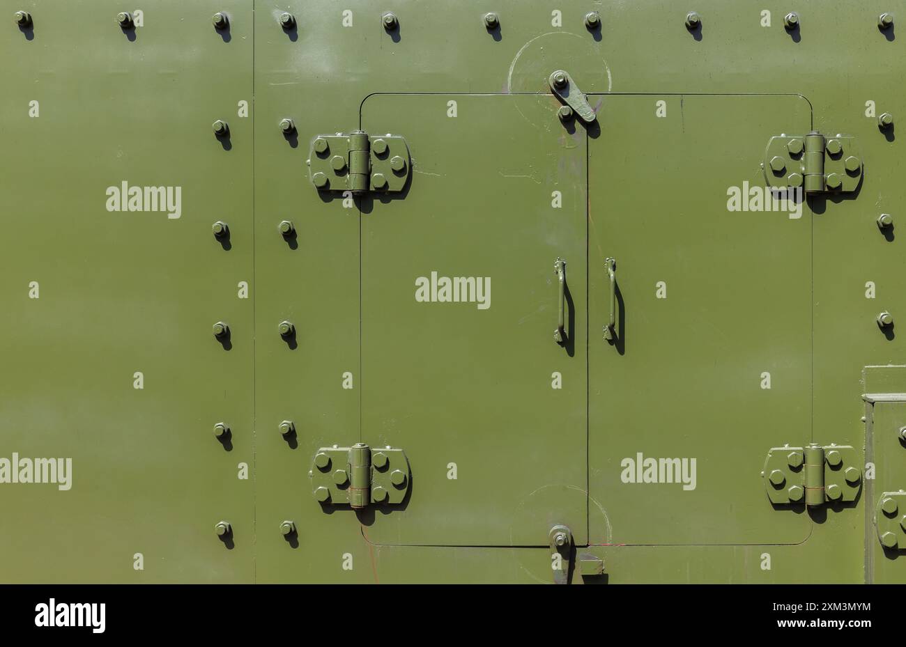 Military green wall with bolts and small doors, background photo ...