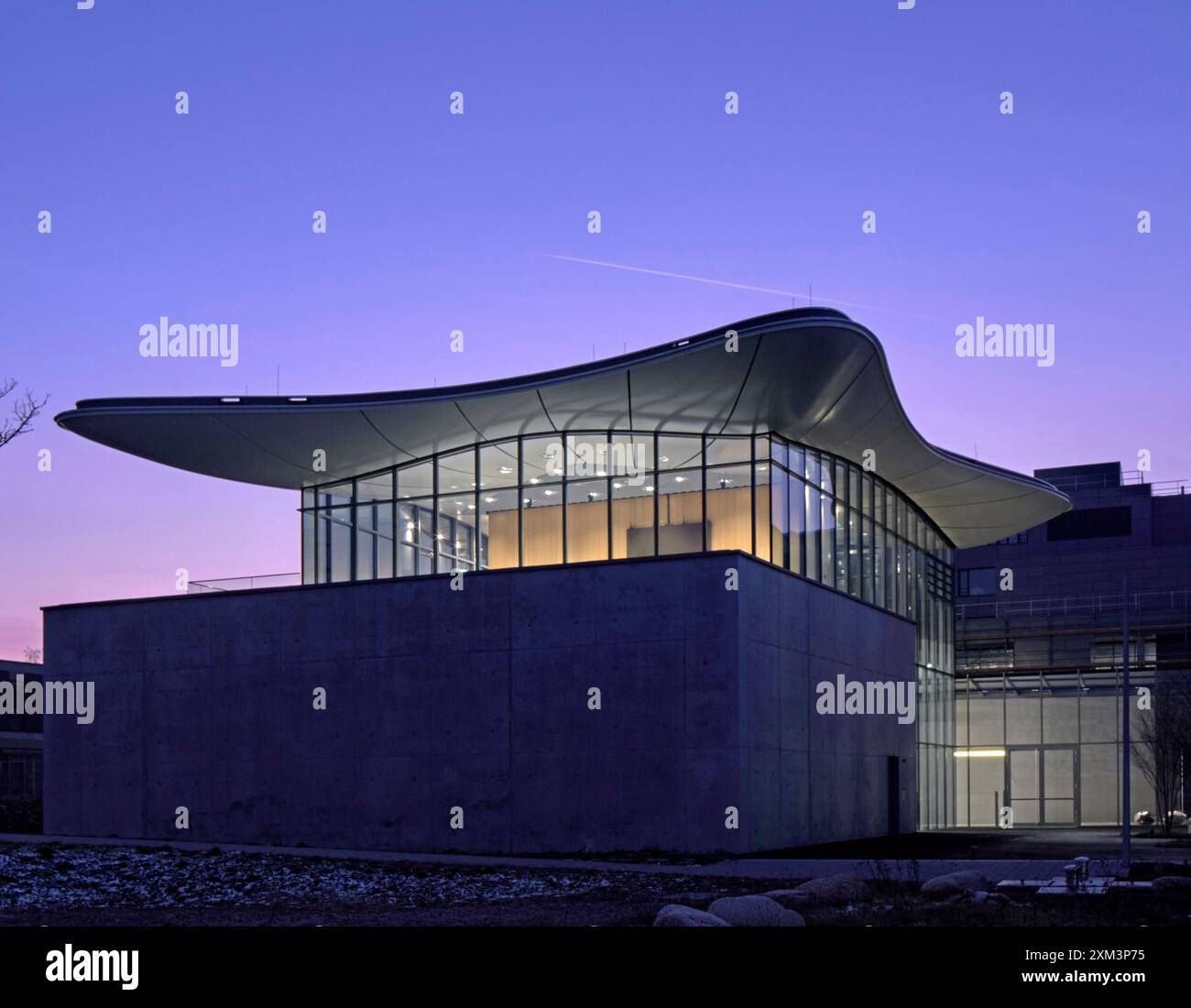 Top floor facade with floating roof, illuminated interiors at dusk ...