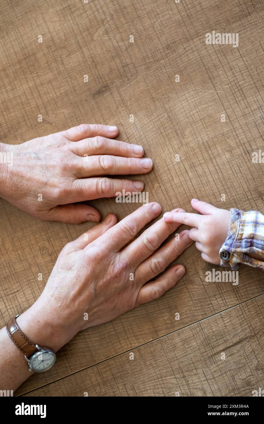 Old female hand holding young baby hand Stock Photo - Alamy