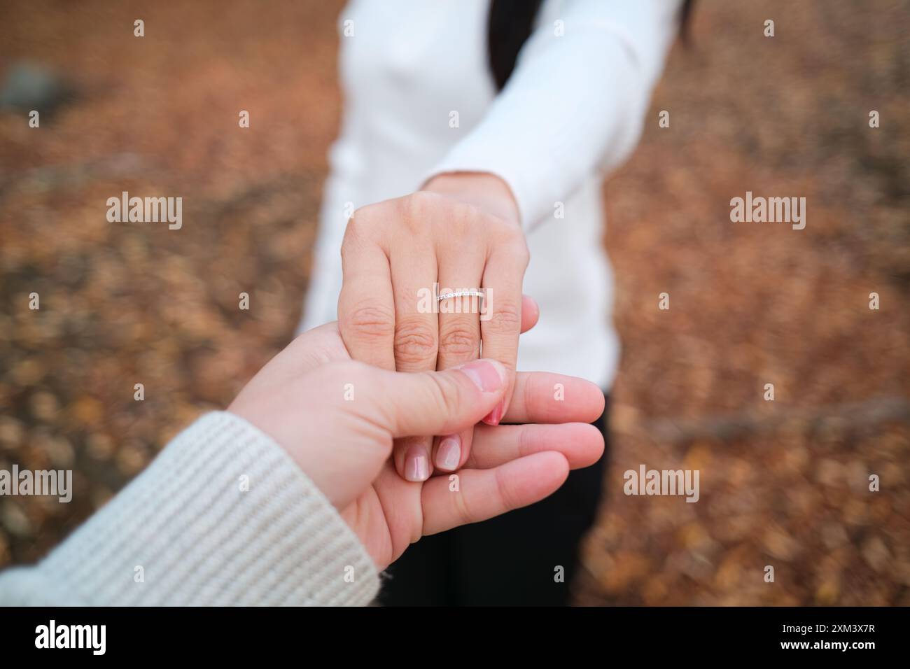 Couple holding hands with a engagement ring on the bride finger. POV ...