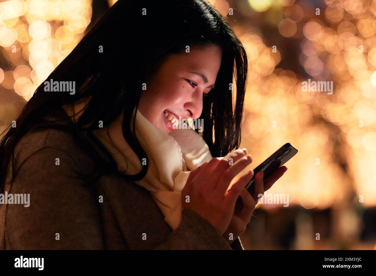 Asian Woman Smiles While Using Her Cell Phone Stock Photo - Alamy
