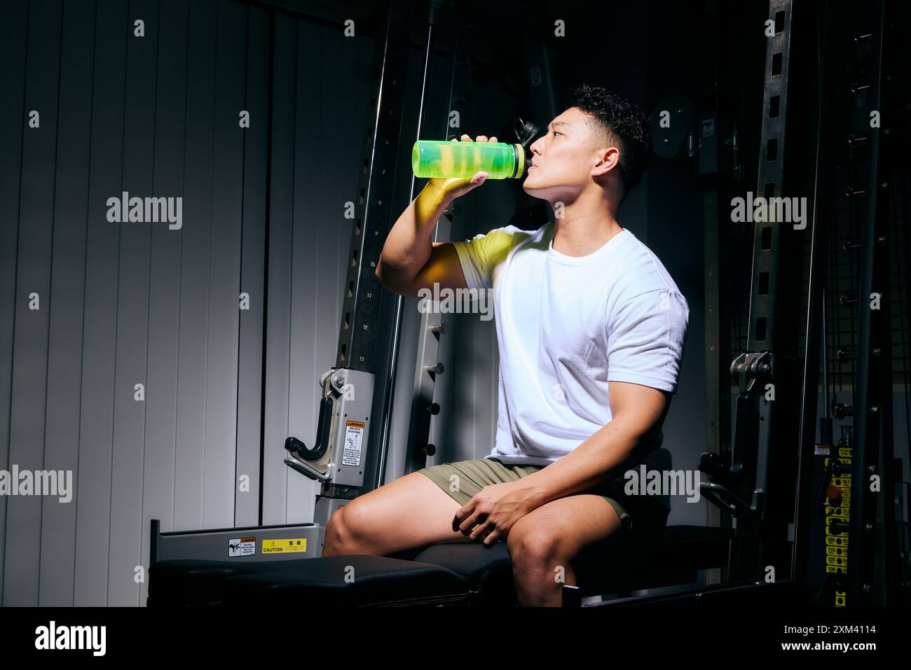 Asian Man Drinking From A Bottle In A Gym Stock Photo - Alamy