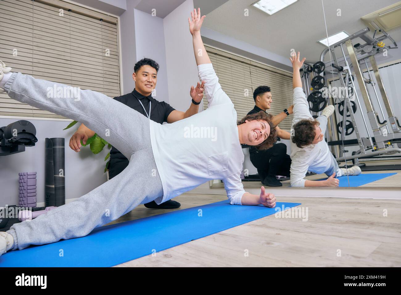 Asian Man Working Out With A Trainer In A Gym Stock Photo - Alamy