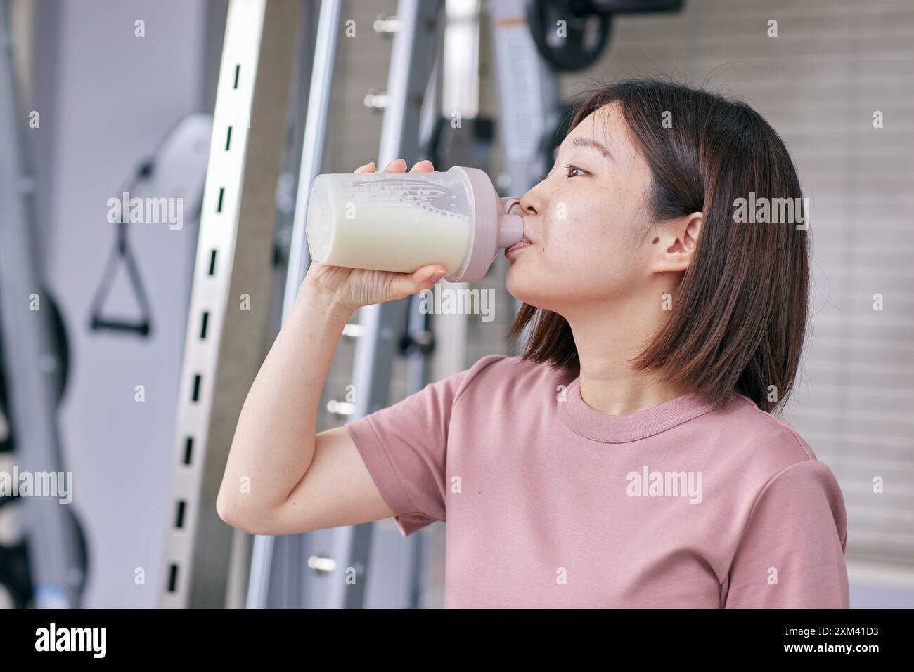 Asian Woman Drinking Protein Shake From A Bottle In A Gym Stock Photo ...