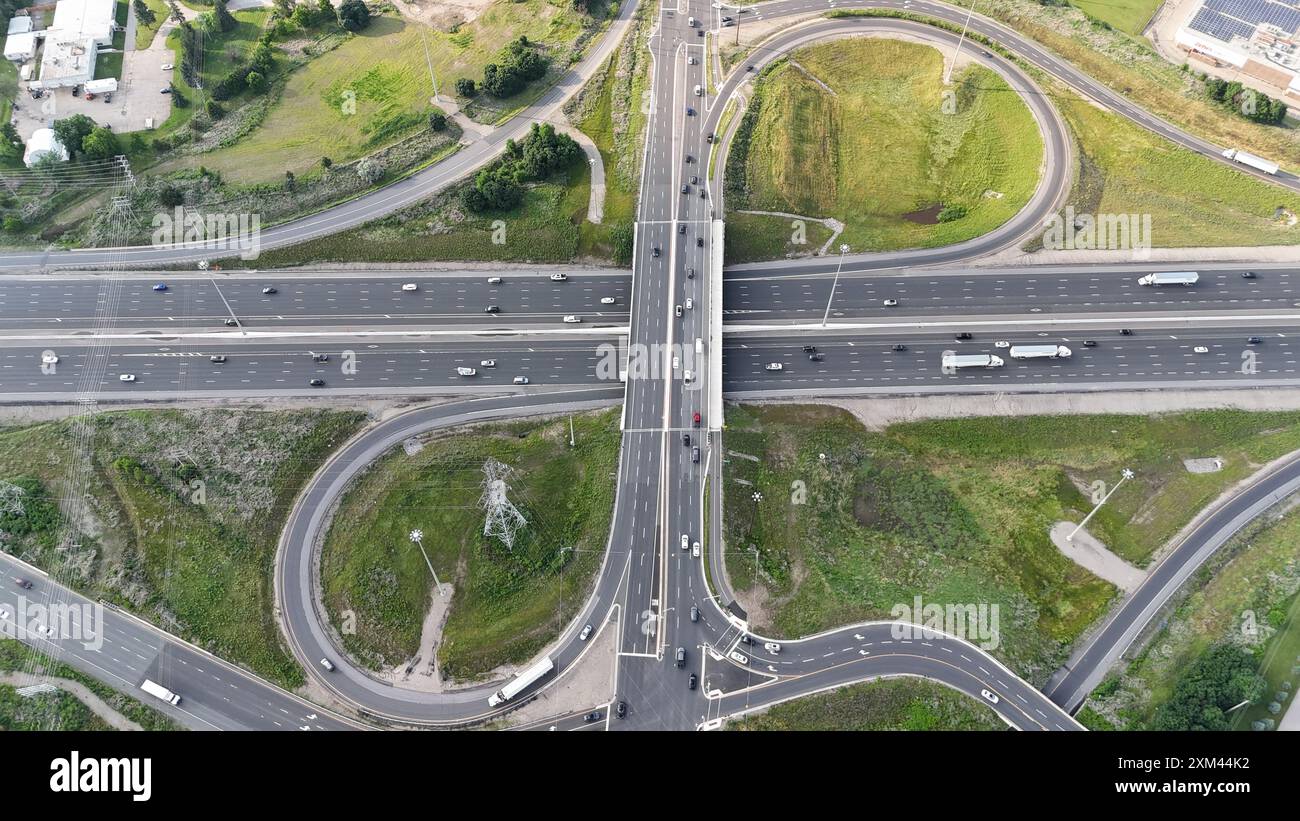 An aerial view of a highway interchange with multiple lanes and green ...