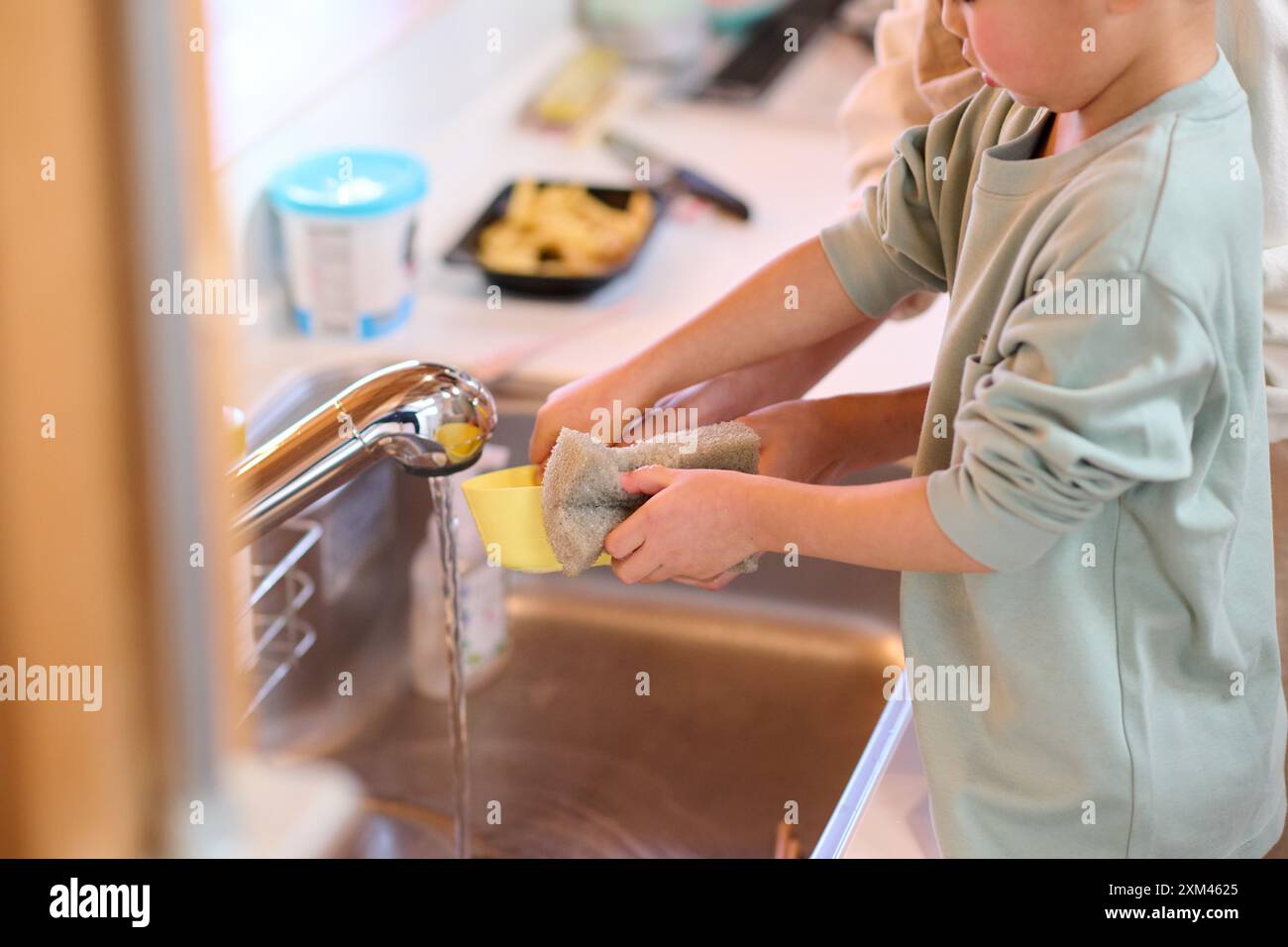 Asian kid washing dishes in a kitchen sink Stock Photo - Alamy