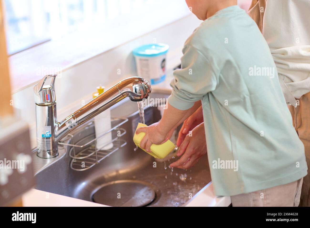Asian kid washing dishes in a kitchen sink Stock Photo - Alamy