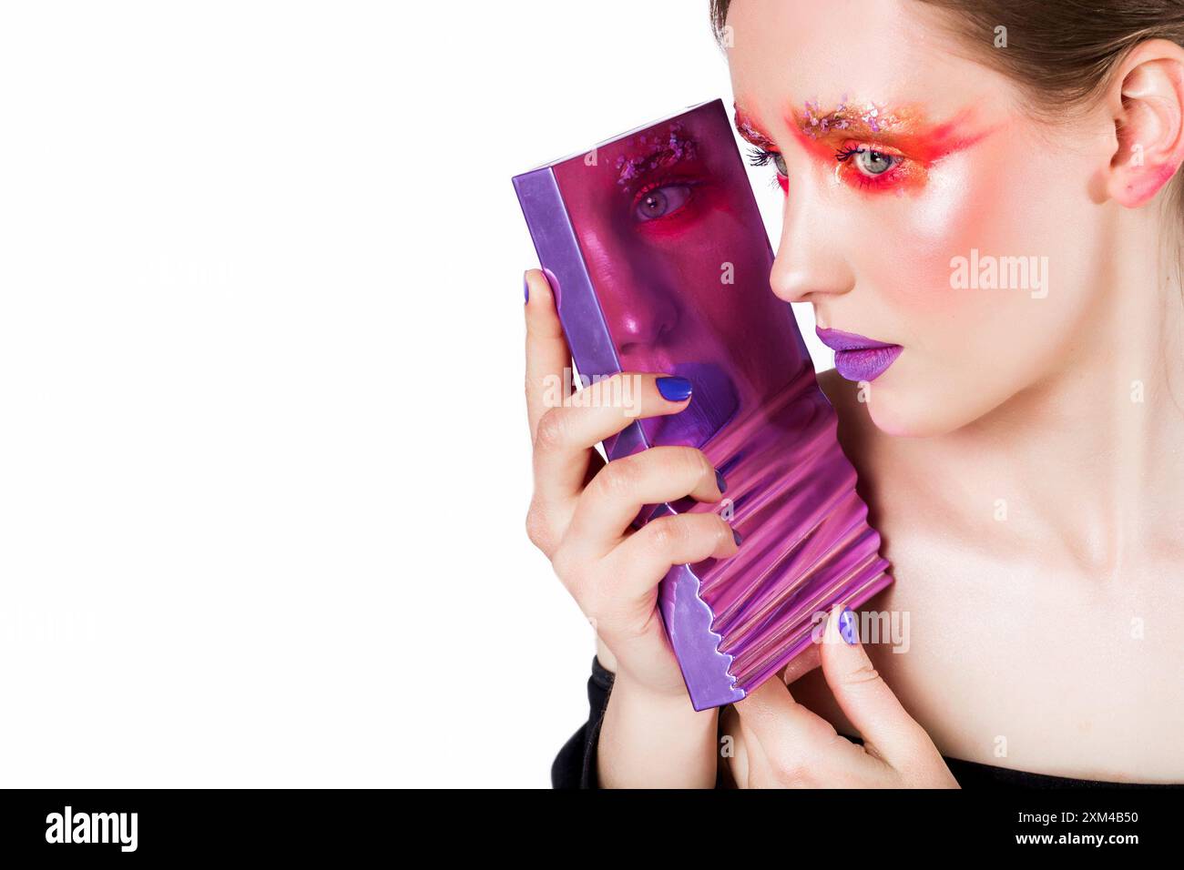 A woman with bold, creative eye makeup and vibrant purple lipstick ...