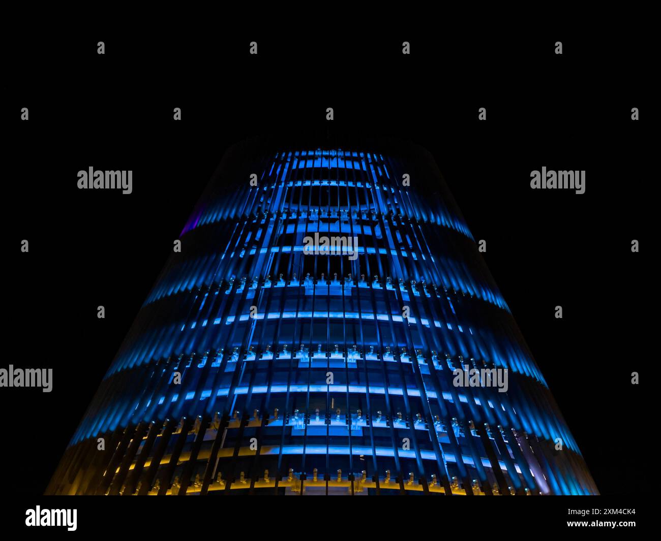 Modern architectural building illuminated with blue lights against a ...