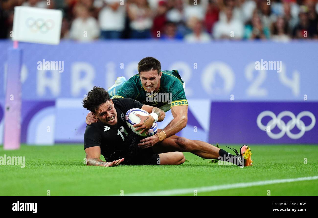 New Zealand's Leo Moses scores a try during the rugby sevens match ...