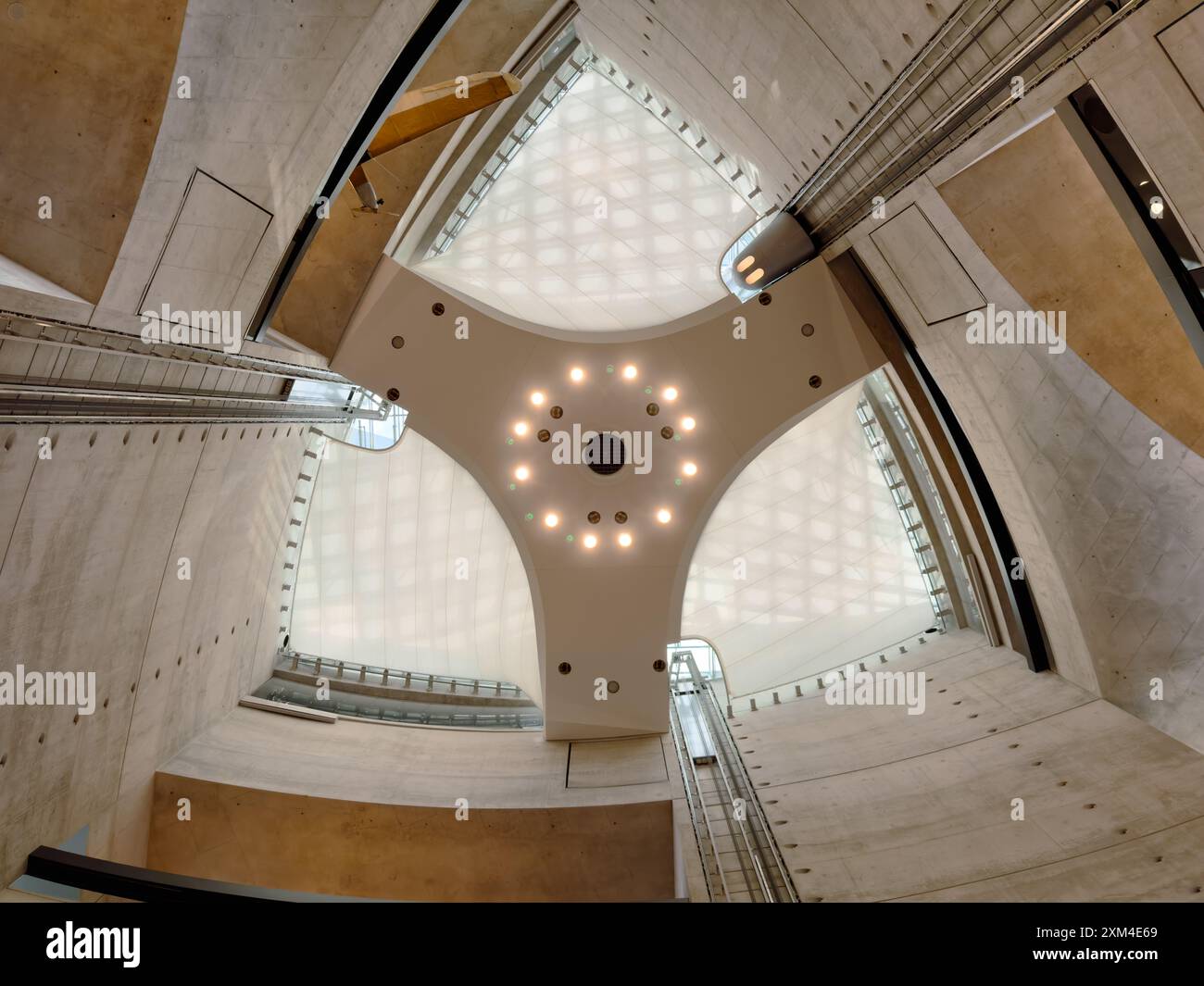 Interior view of a modern atrium with a geometric ceiling and concrete ...